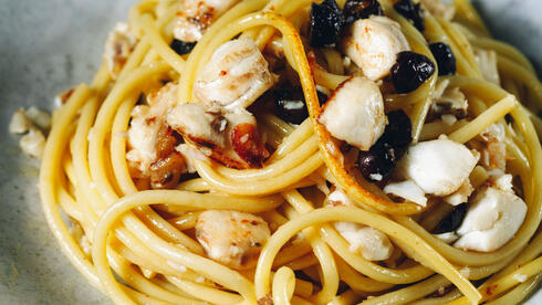 Fresh basil fish pasta with white wine and kalamata olives
